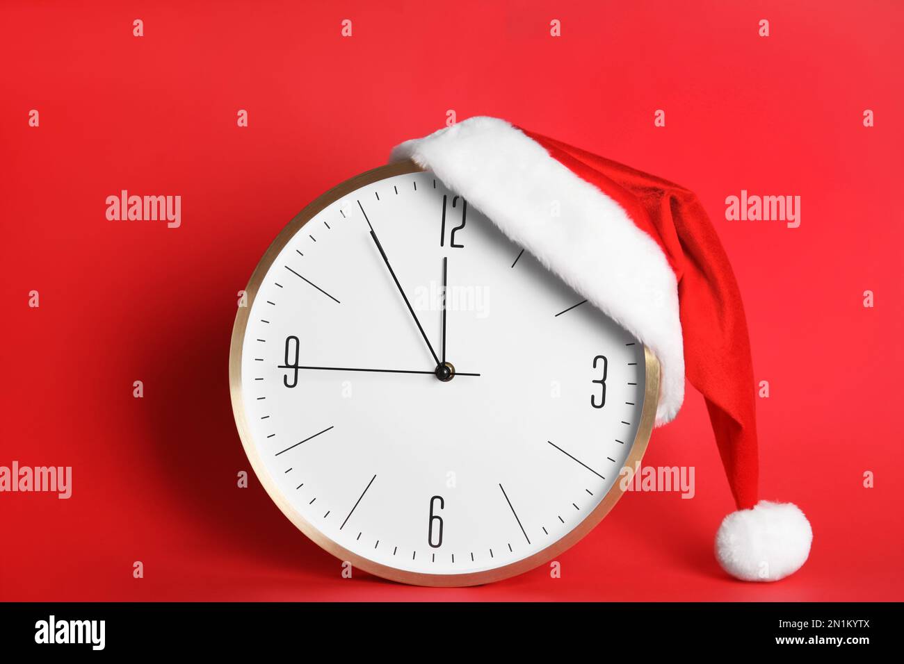 Clock with Santa hat showing five minutes until midnight on red ...