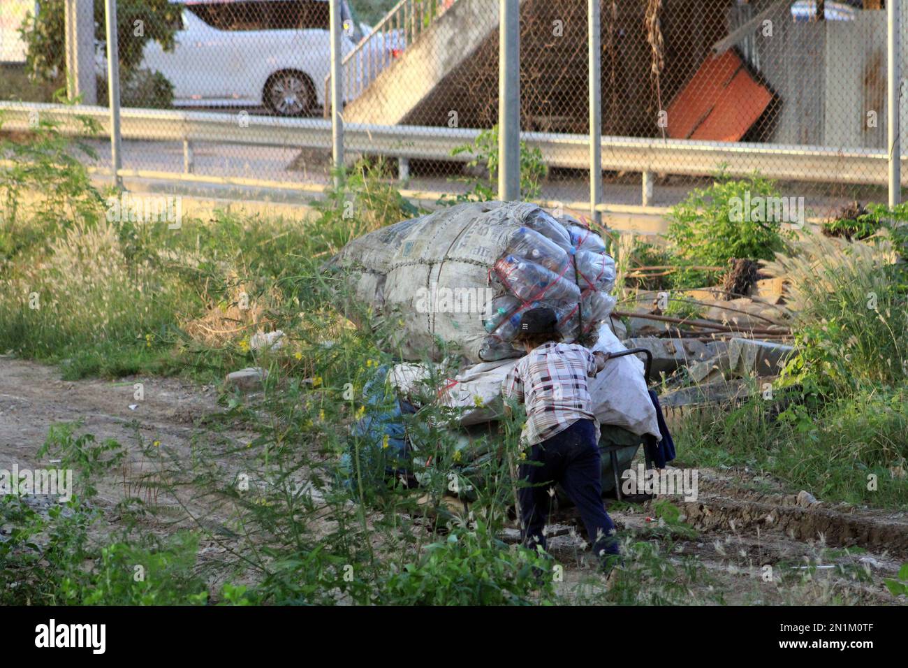 KANCHANABURI, THAILAND - MARCH 21, 2018 man pushing an overloaded cart ...