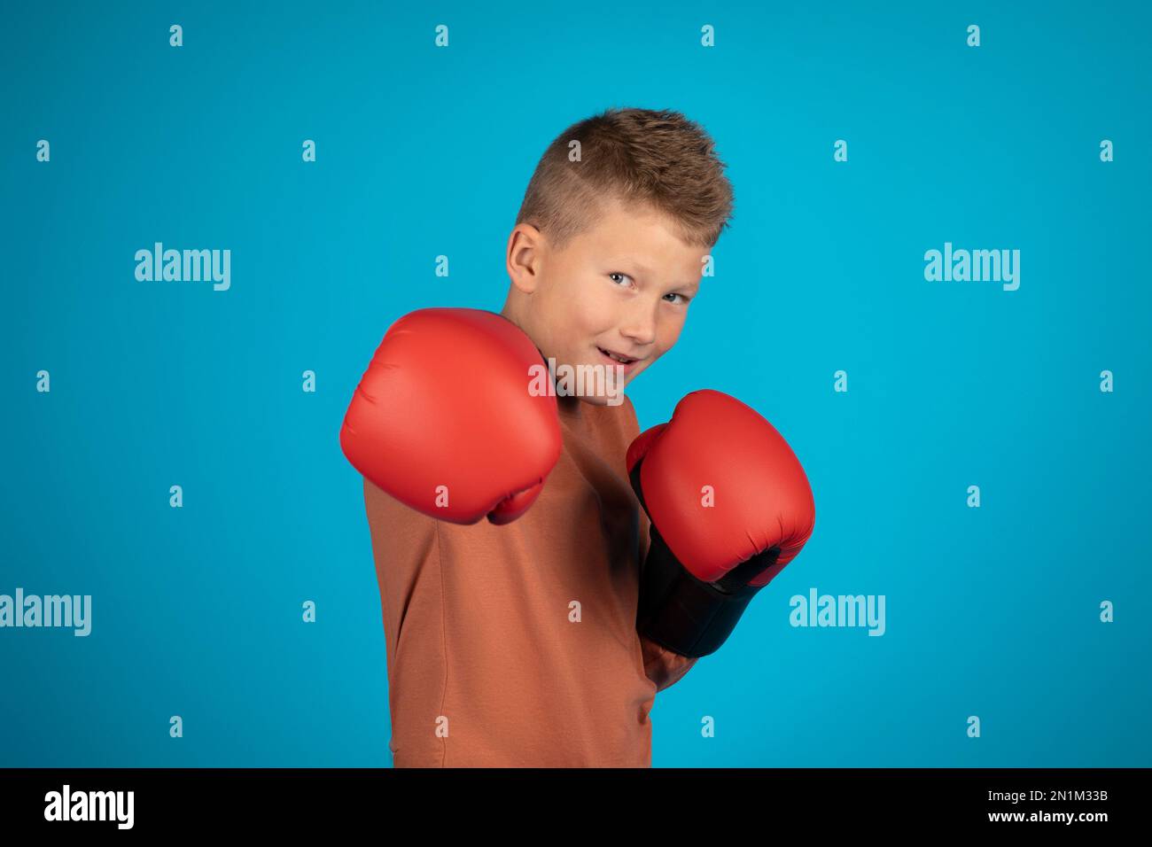 Sporty Male Kid Wearing Boxing Gloves And Making Punch At Camera Stock ...