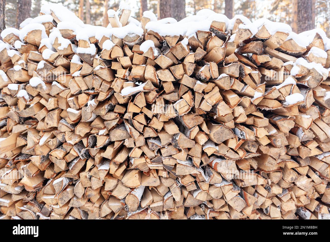 Stacked Firewood Covered With White Snow Wood For Kindling And Heating