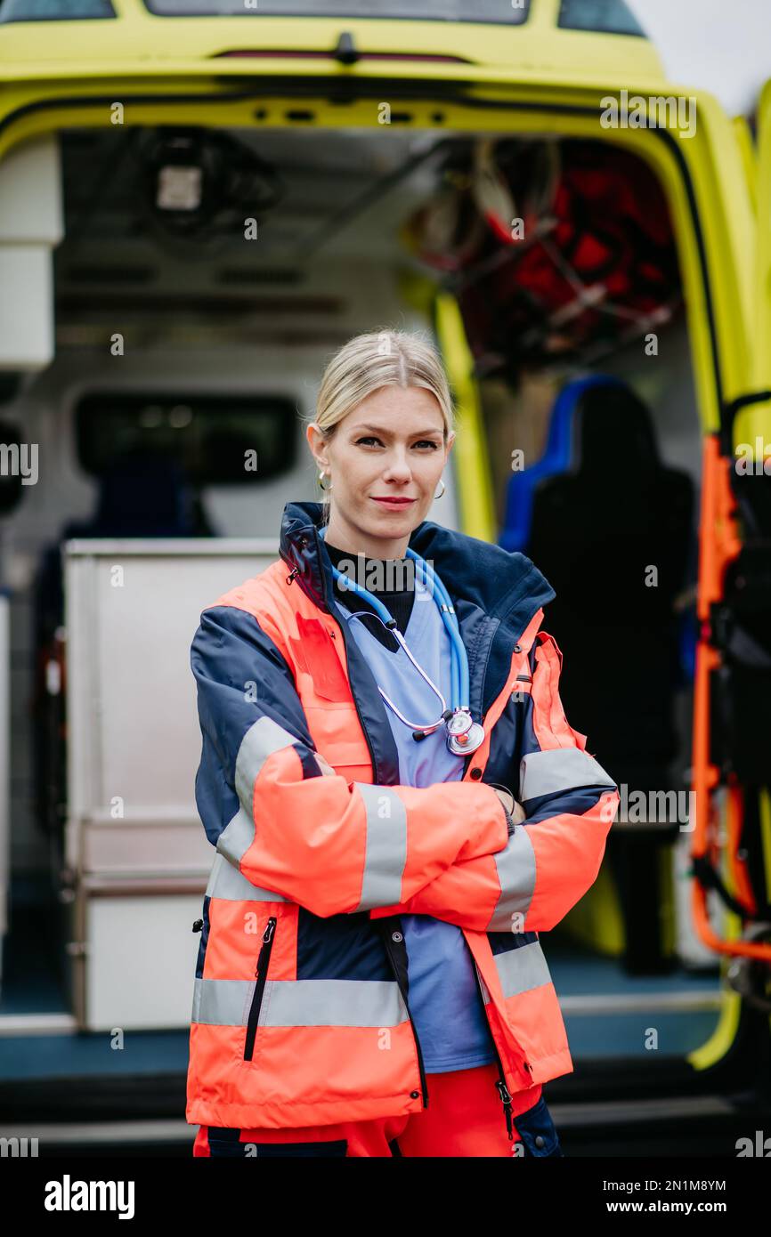 Portrait of young woman doctor standing in front of ambulance car Stock ...