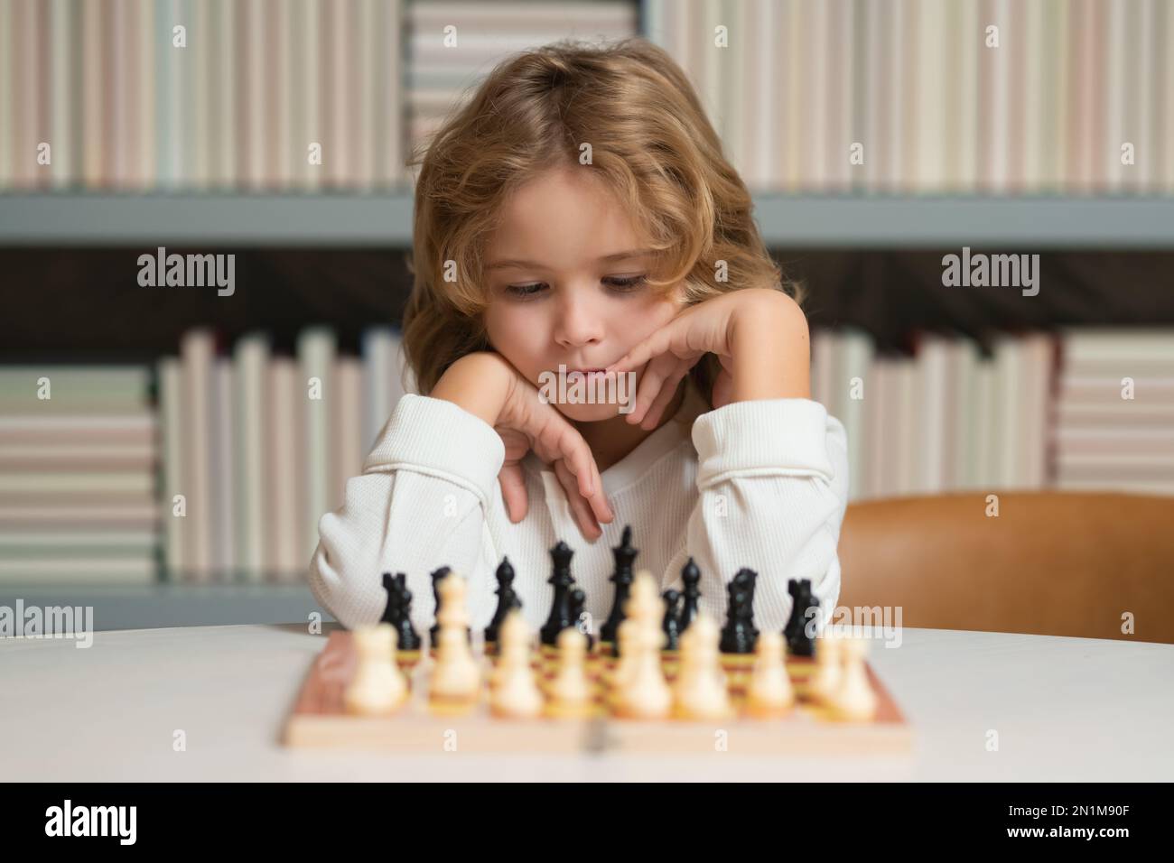Clever concentrated and thinking kid boy playing chess Stock Photo - Alamy