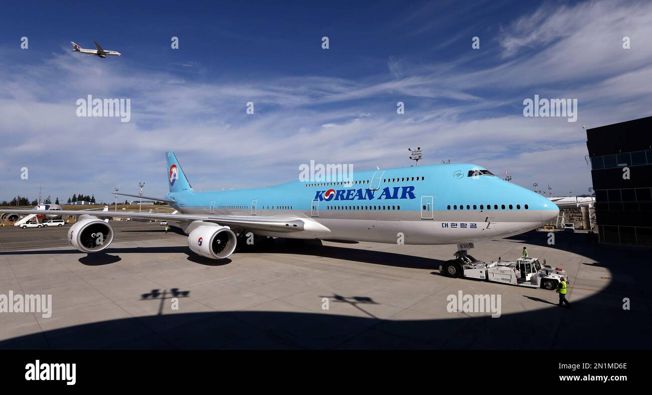 As another plane flies overhead, a Boeing 747-8 Intercontinental jet is ...