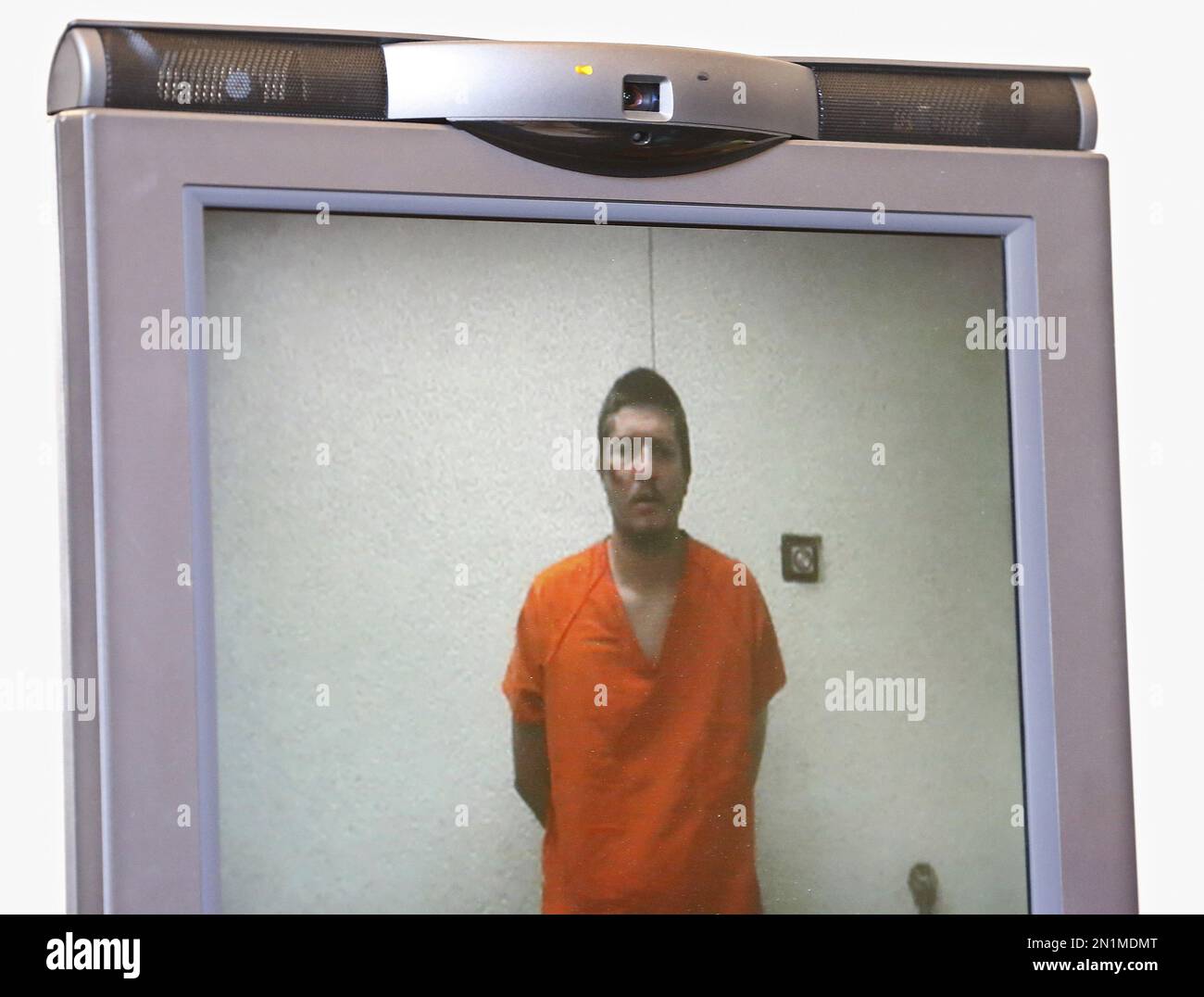 Christian Costello is pictured on a video screen as he appears before ...