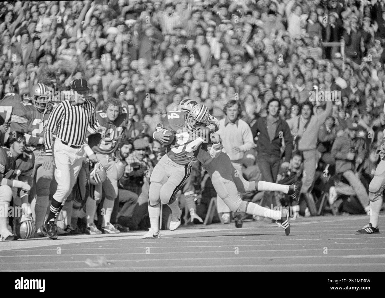 Ohio State tailback Jeff Logan holds the ball as he tries to squirm ...