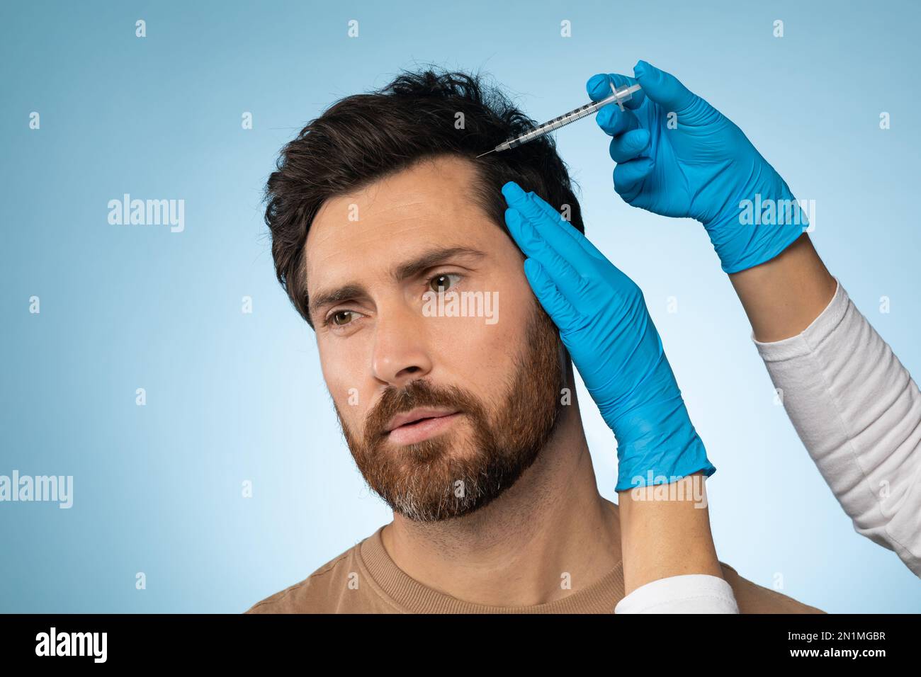 Mesotherapy for hair. Middle aged man getting injections in head ...