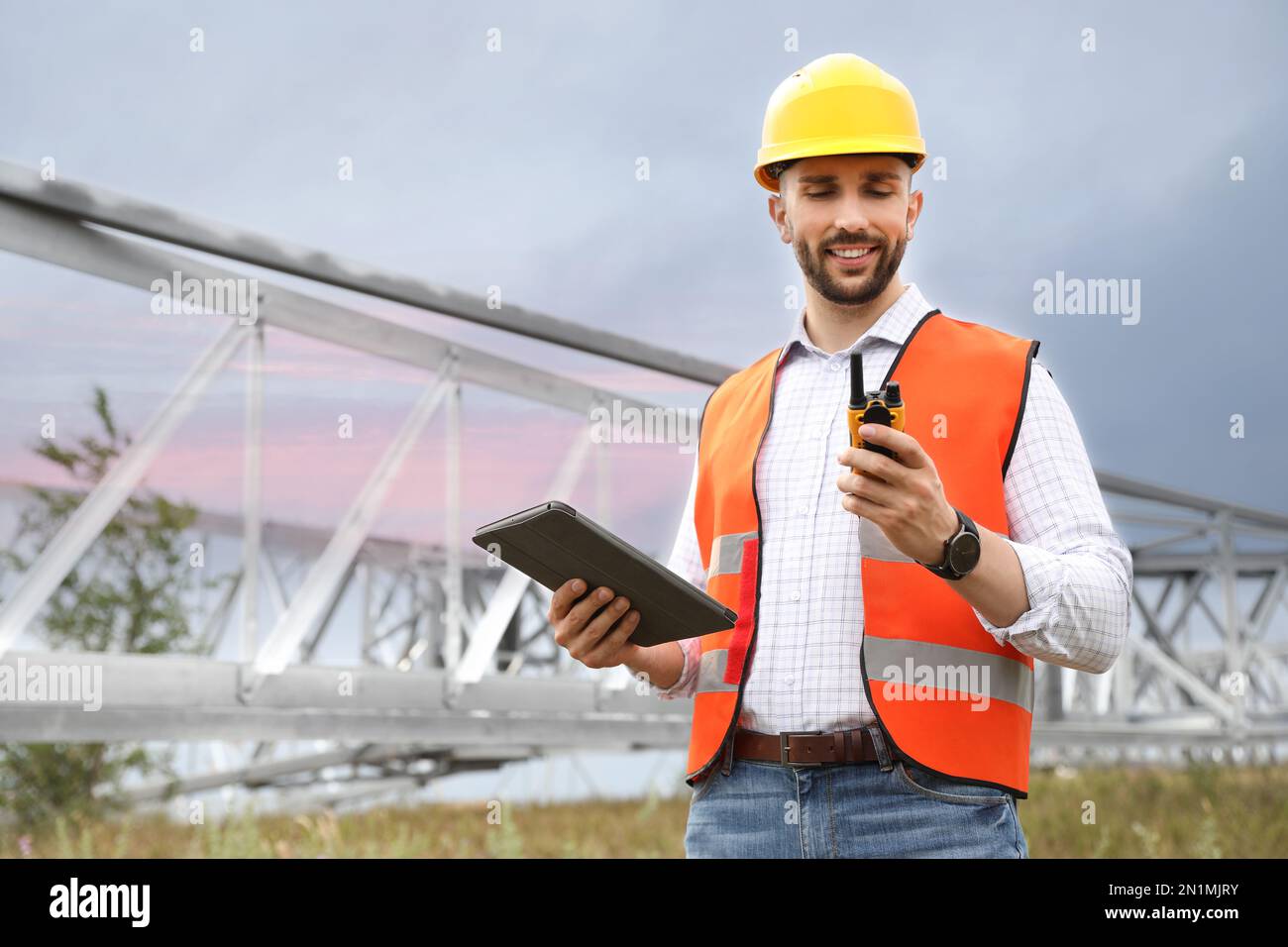 Professional engineer with tablet and walkie talkie near high voltage ...