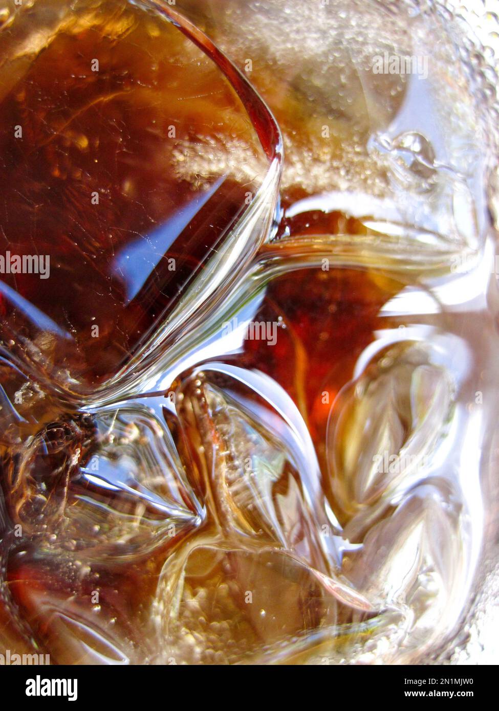 Close-up of the reflections and textures of some ice cubes on a soda ...