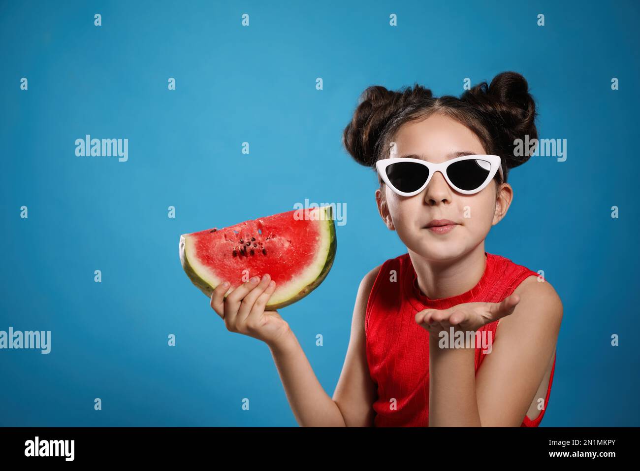 Cute little girl with watermelon on blue background Stock Photo - Alamy