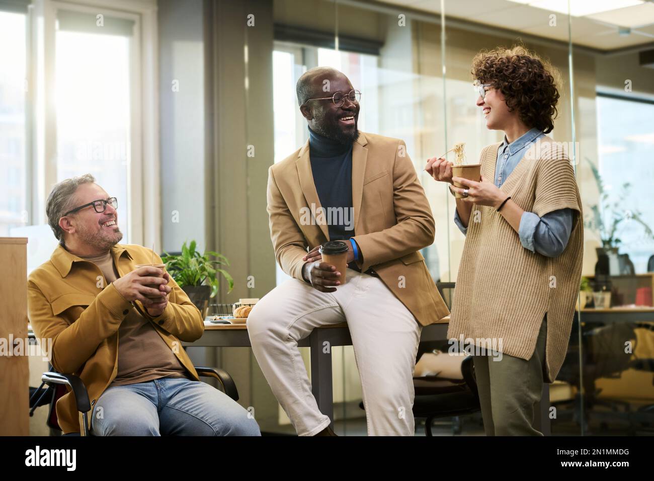 Group of cheerful intercultural office managers having coffee and ...