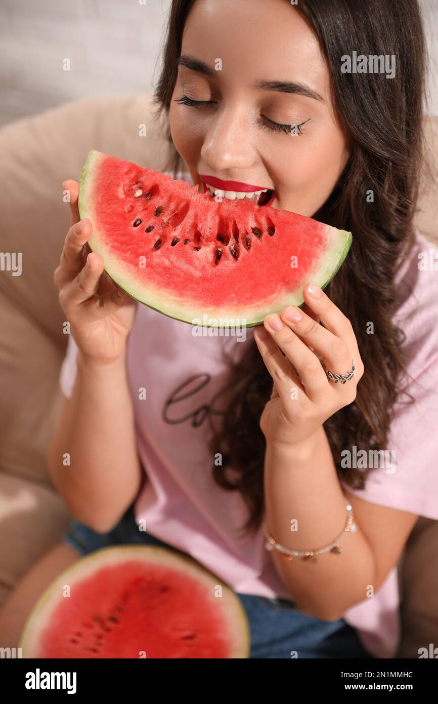 Beautiful young woman with watermelon on chair Stock Photo - Alamy