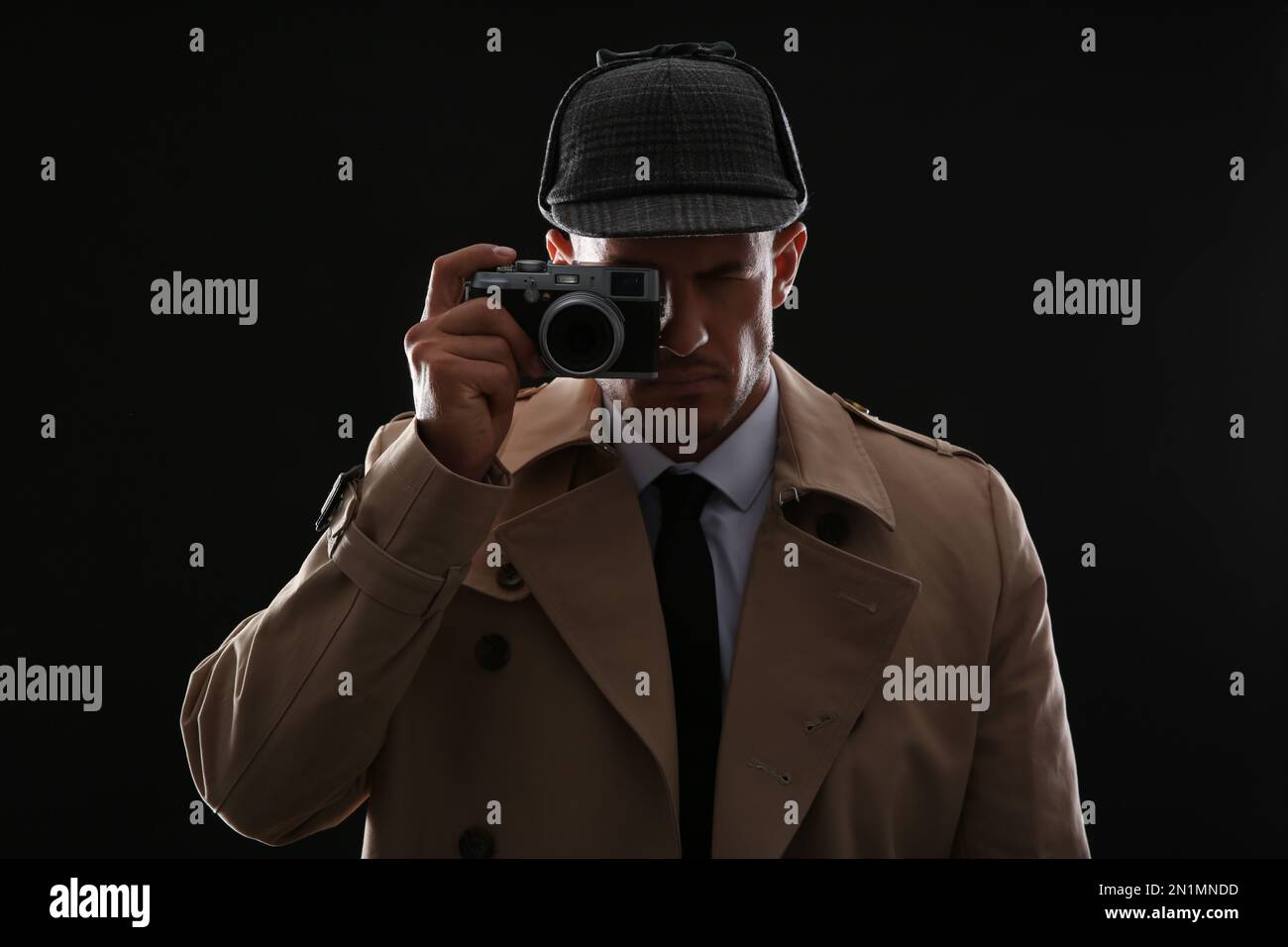 Old fashioned detective with camera on dark background Stock Photo - Alamy