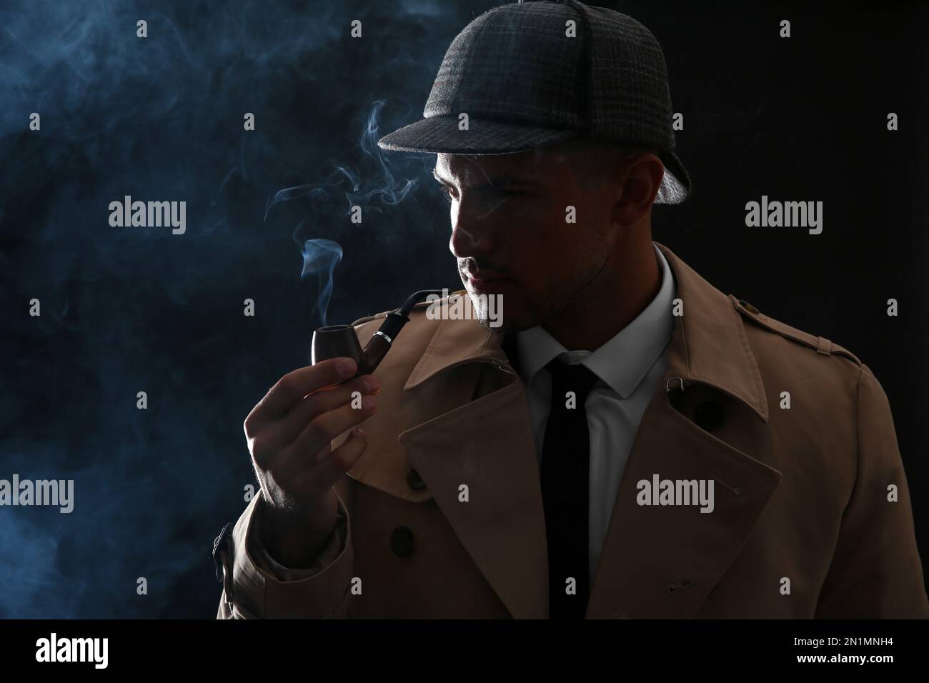 Old fashioned detective smoking pipe on dark background Stock Photo - Alamy