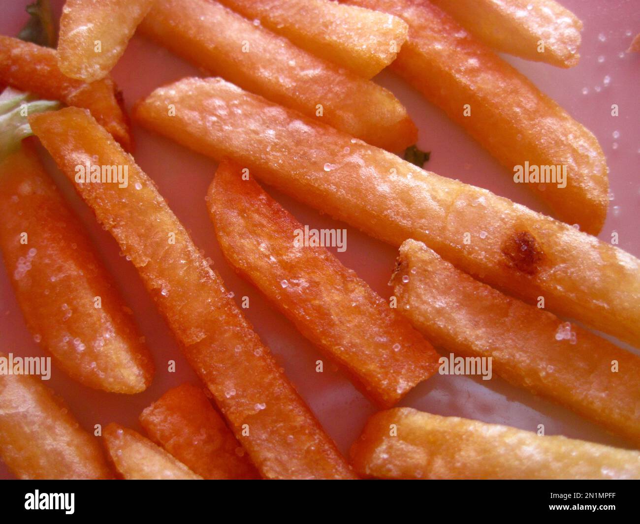 Close up of a handful of well browned potato chips in the shape of ...