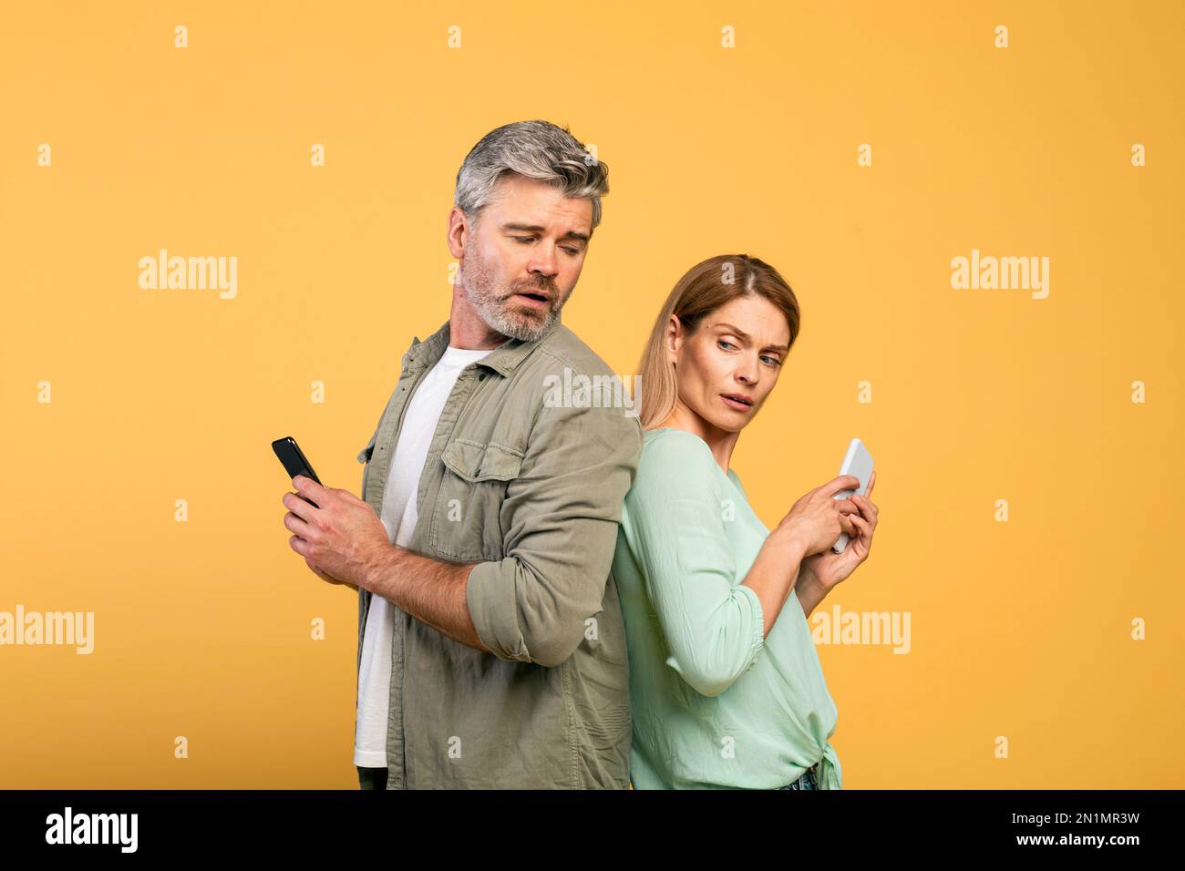 Privacy concept. Middle aged caucasian man trying to look at his wife's ...
