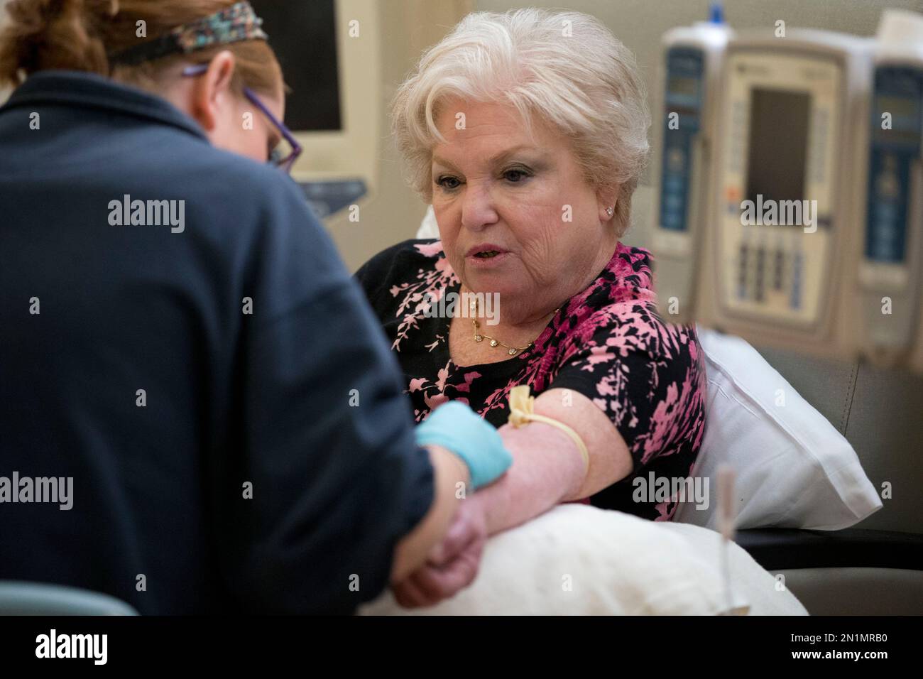 Nurse Caitlin Fanning, left, inserts an IV for Judith Bernstein's ...