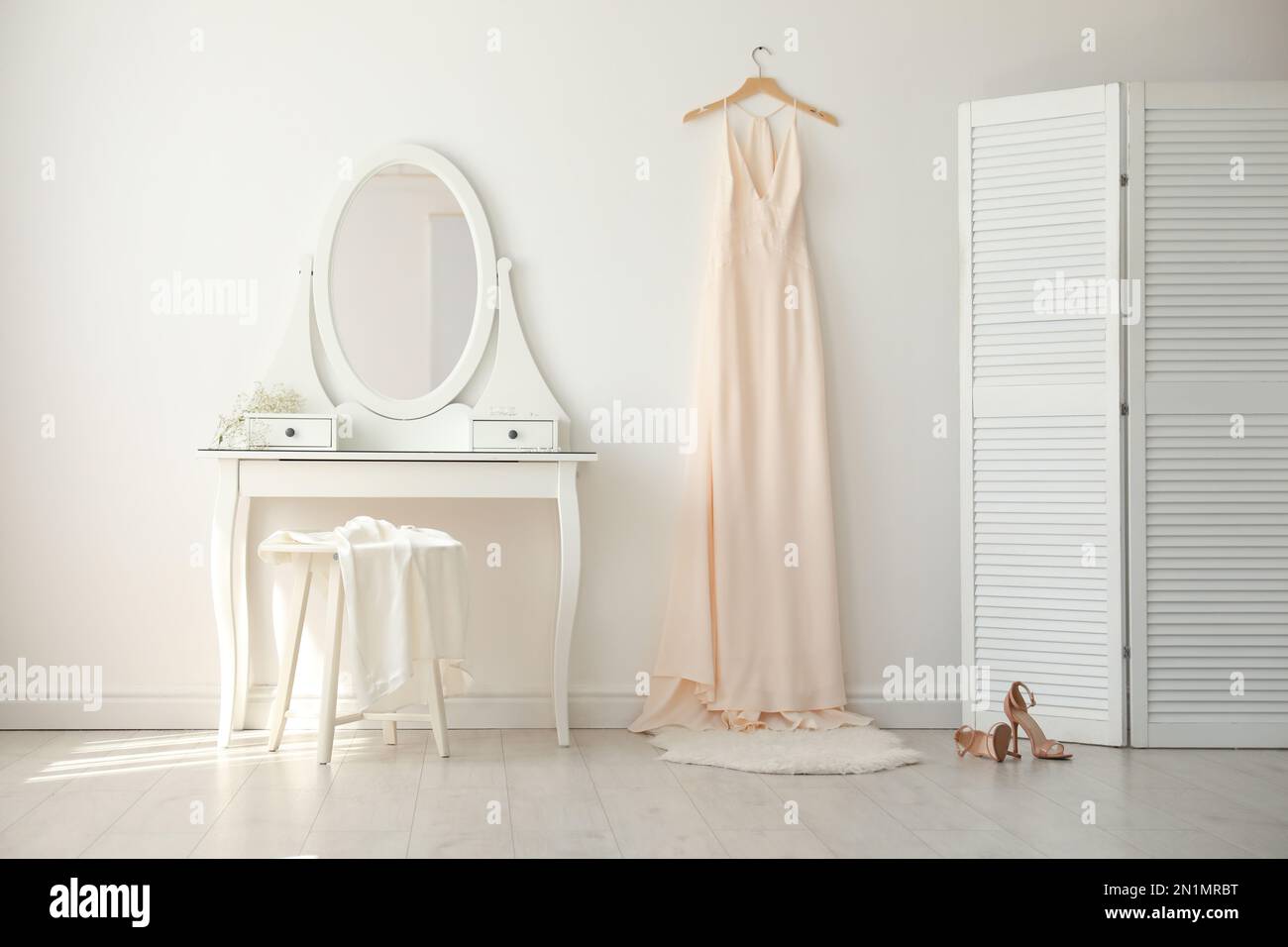 Beautiful wedding gown hanging near dressing table in room Stock Photo ...