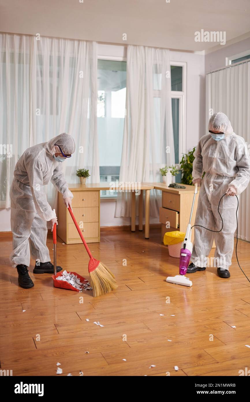 Cleaning service workers wiping floor and desinfecting surfaces in ...