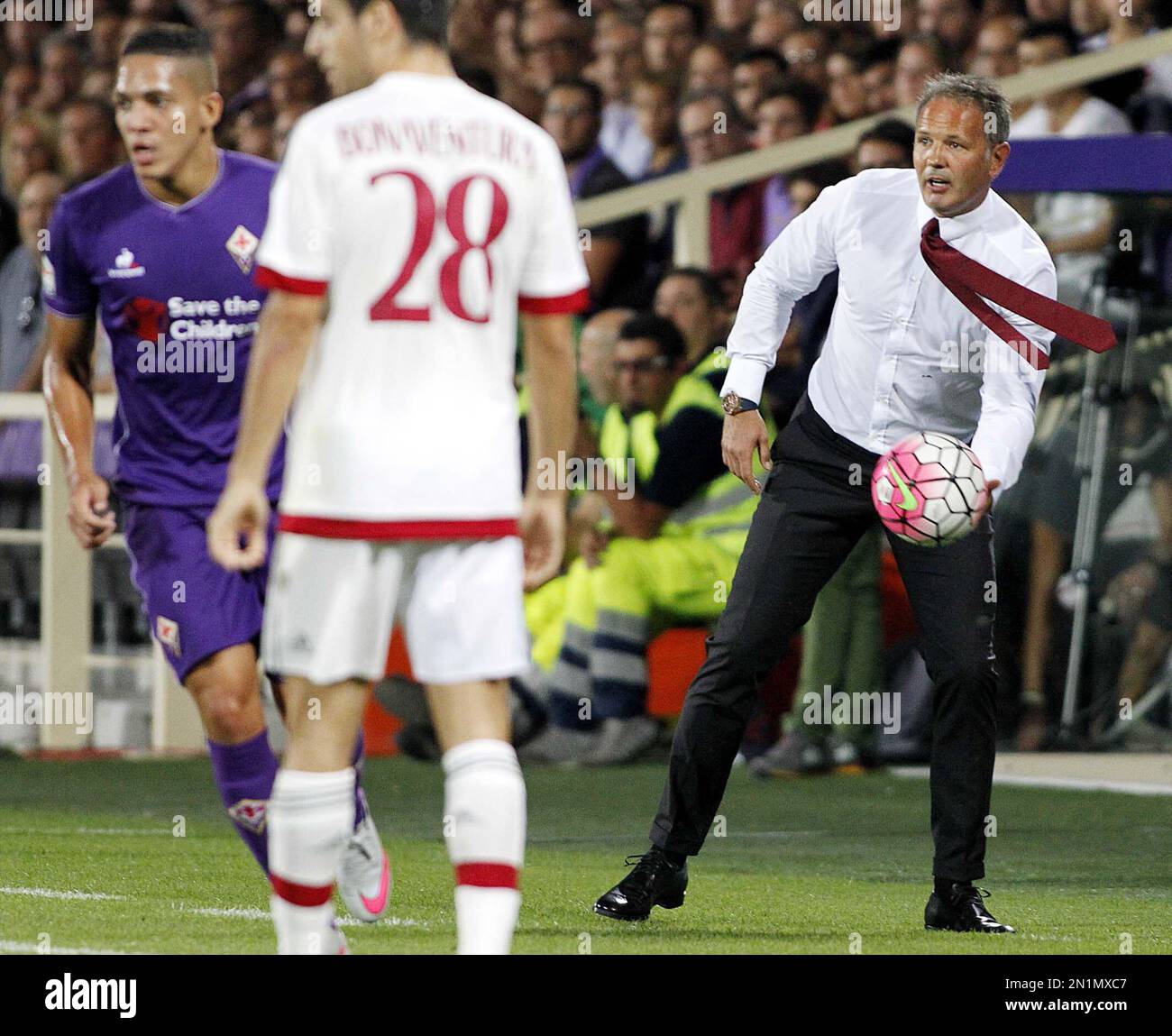 AC Milan coach Sinisa Mihajlovic, right, holds the ball during a Serie ...