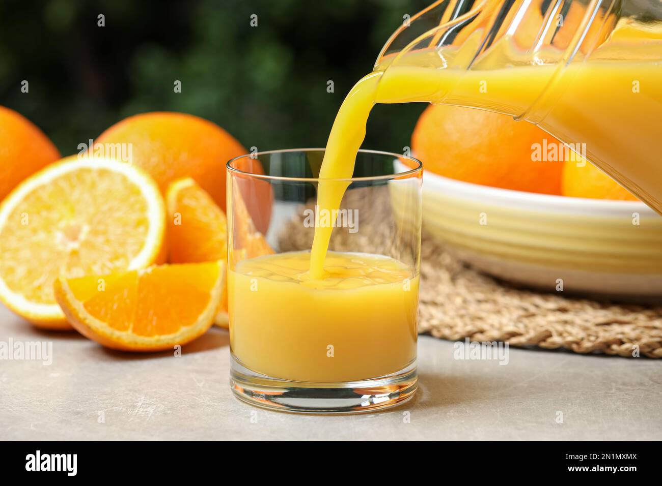 Pouring orange juice into glass at light table, closeup Stock Photo - Alamy