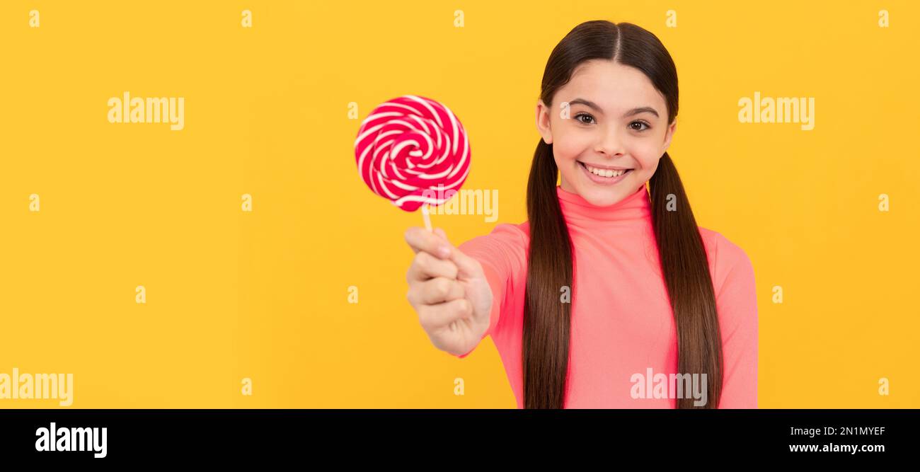 happy teen girl with lollipop candy on stick on yellow background ...