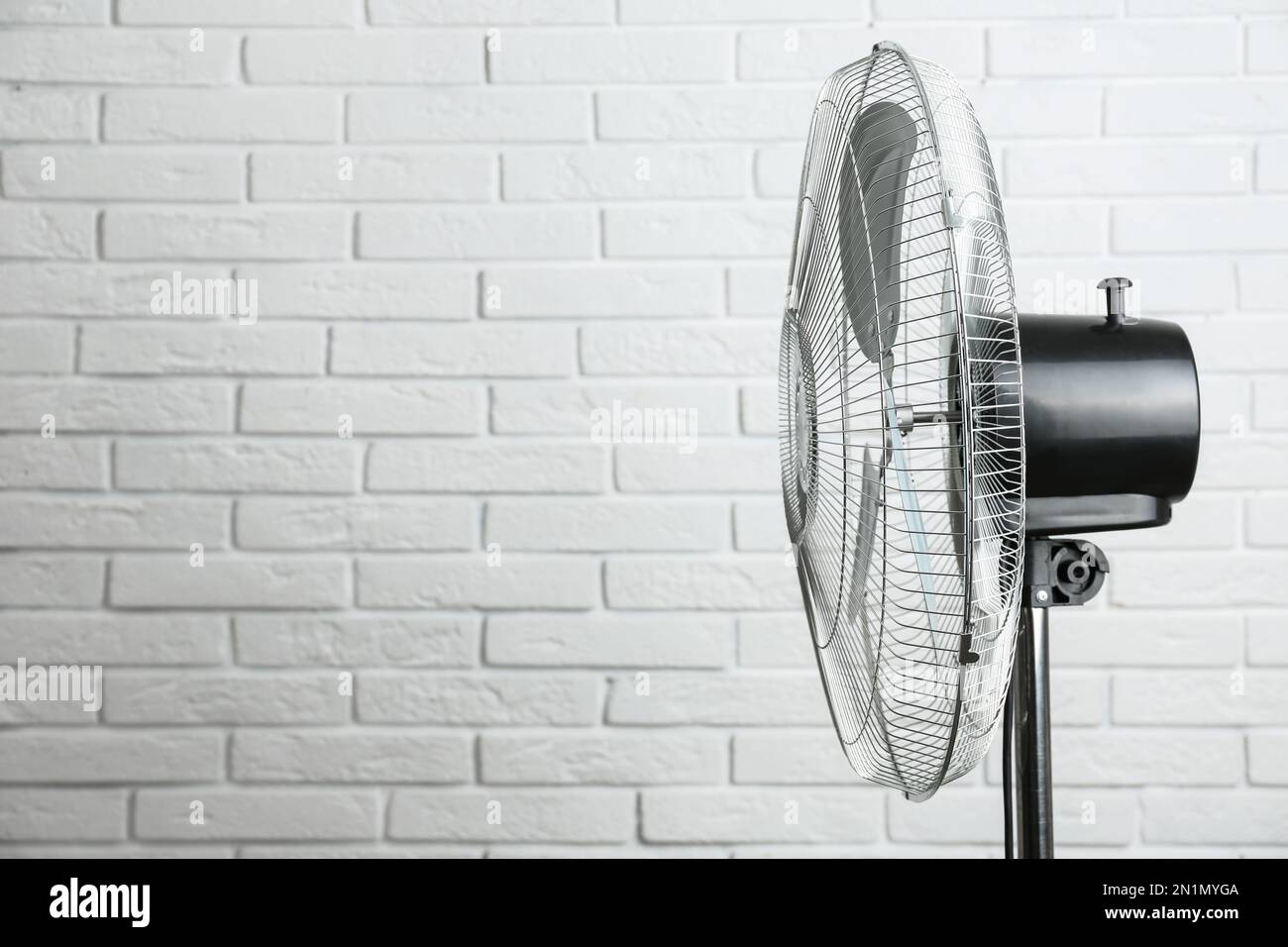 Electric fan near white brick wall, space for text. Summer heat Stock ...