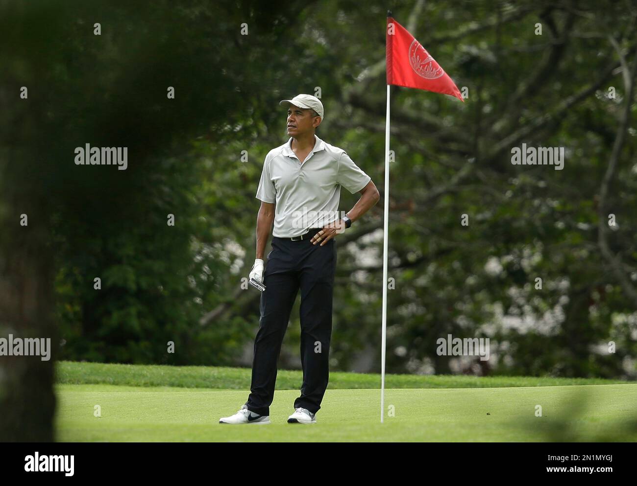 President Barack Obama stands on the green near the the flag stick ...