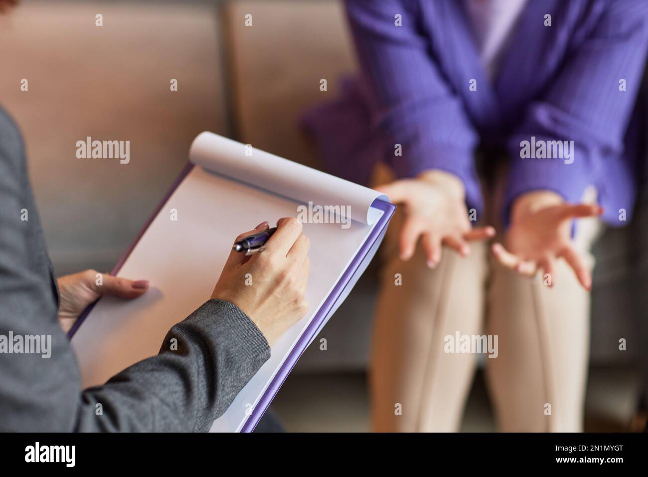 Family psychologist taking notes in document when talking to married ...