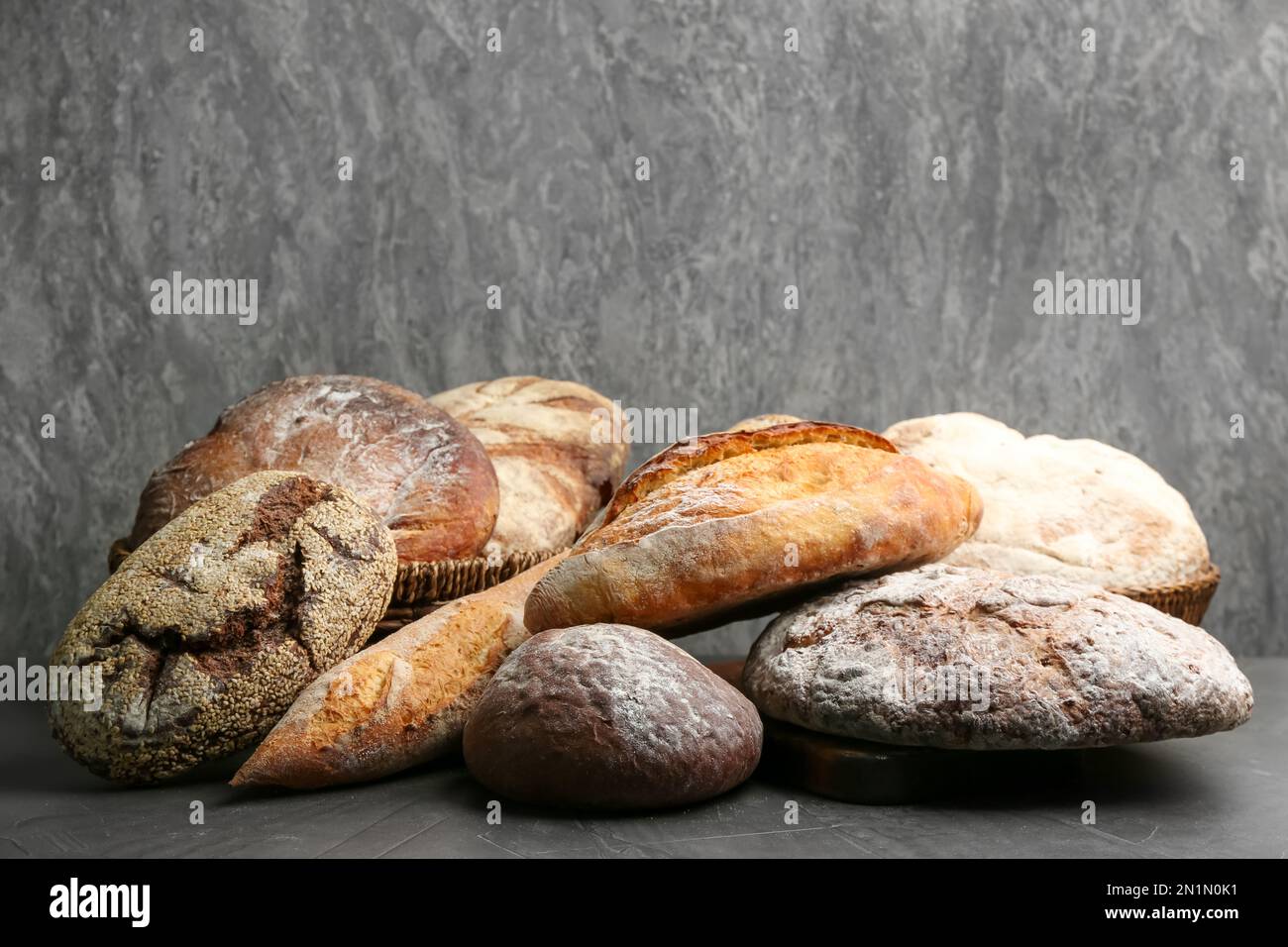 Different kinds of fresh bread on grey table Stock Photo - Alamy