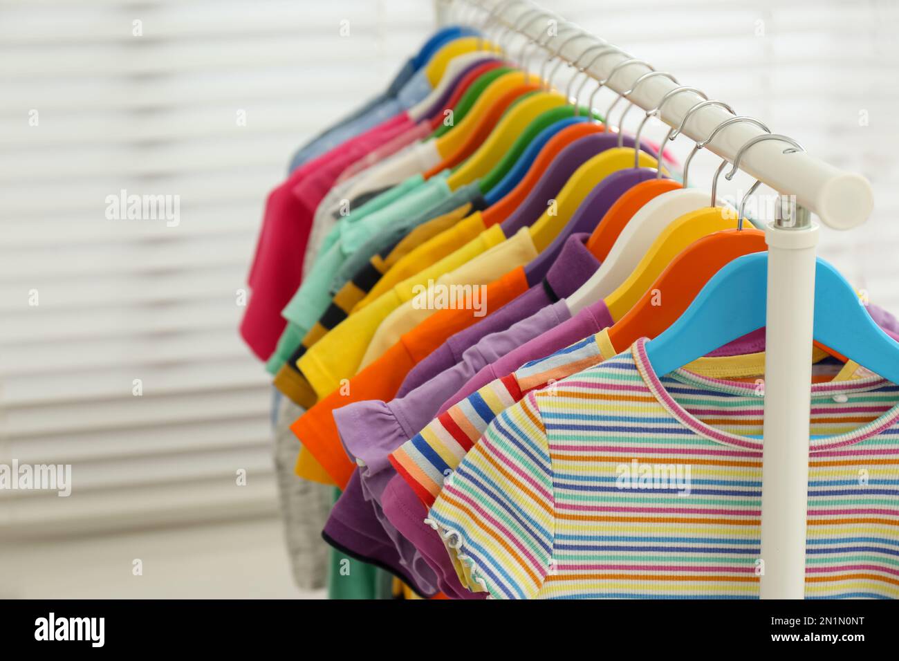 Different child's clothes hanging on rack indoors, closeup Stock Photo ...