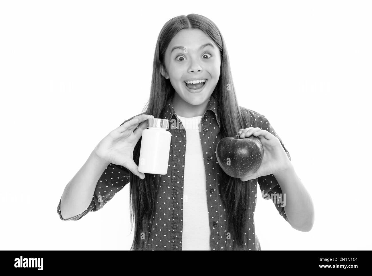 Teen girl with apple and natural food additives or vitamin pills ...