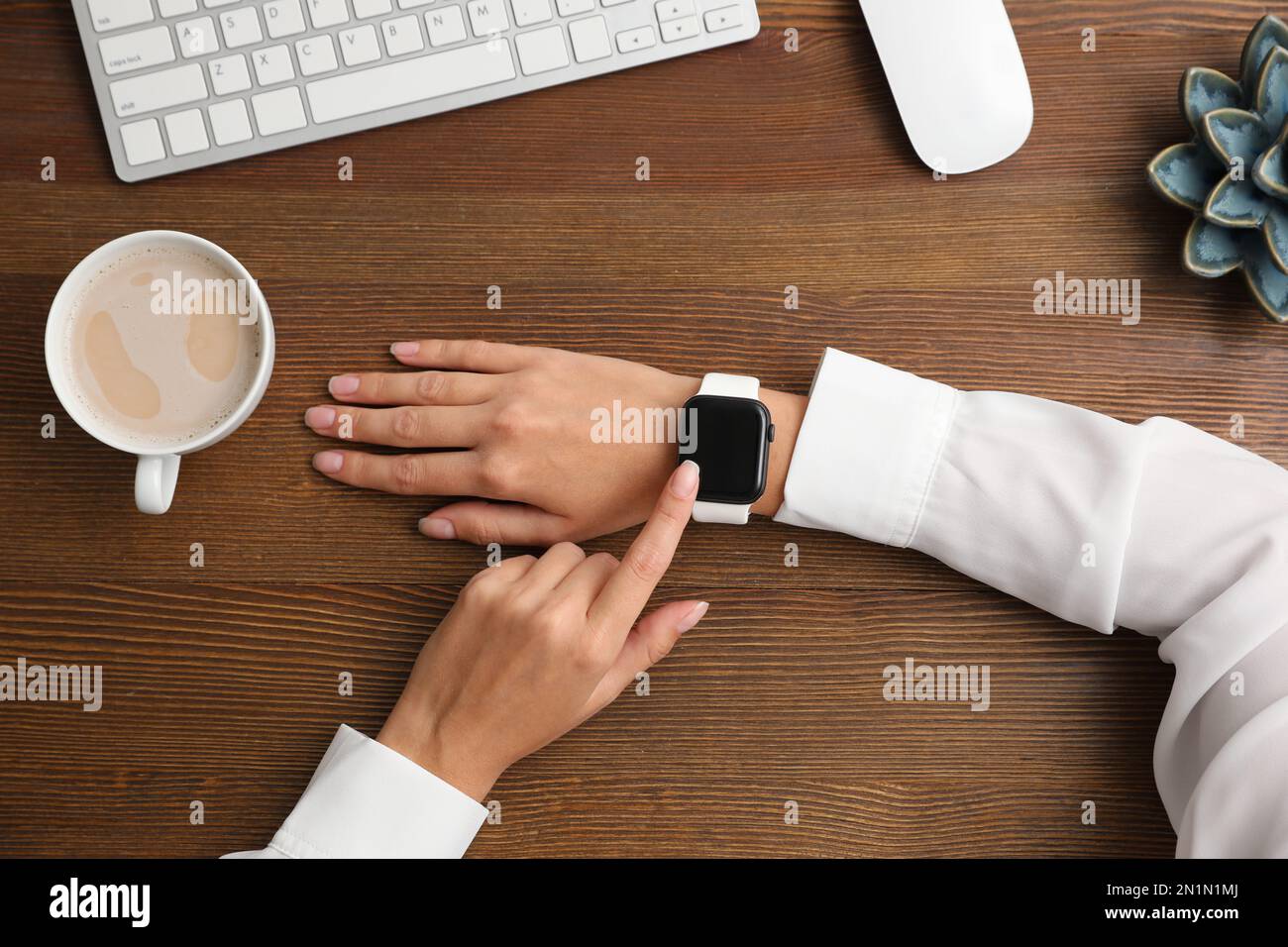 Woman using stylish smart watch at wooden table, top view Stock Photo ...