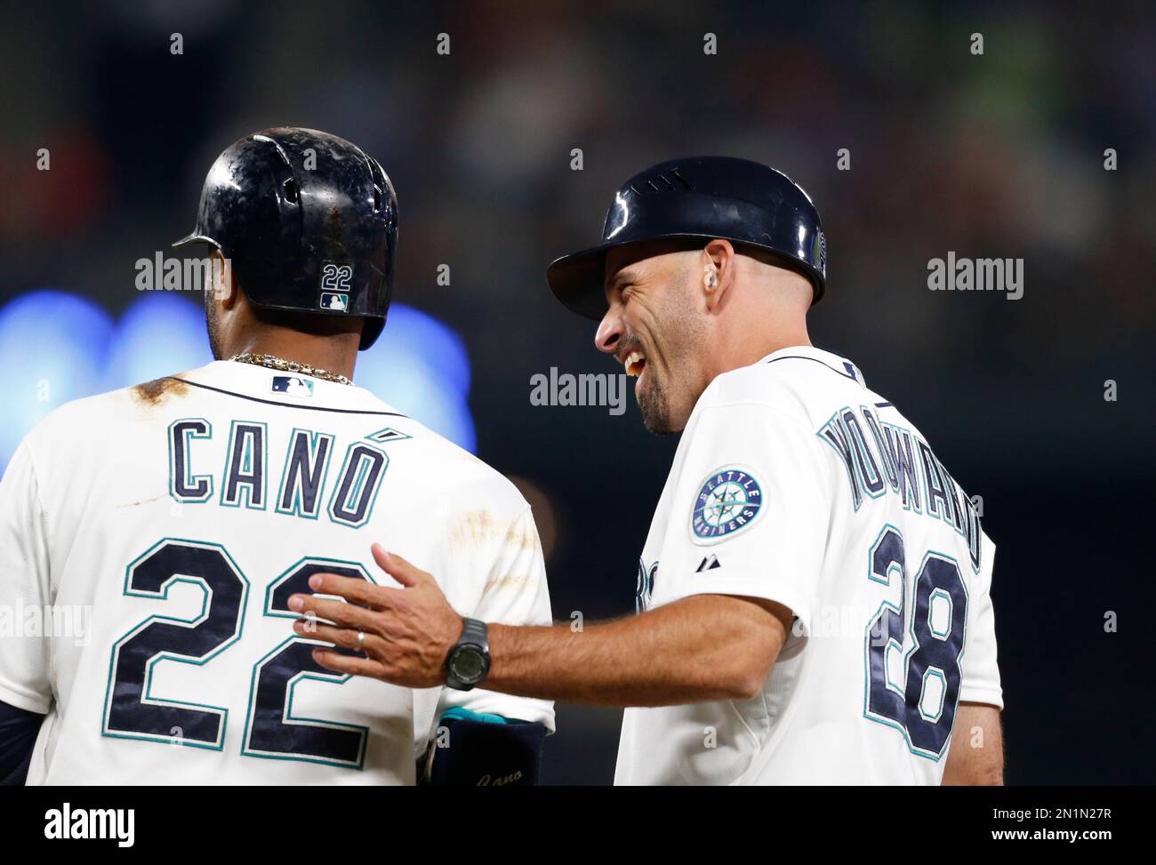 Seattle Mariners first base coach Chris Woodward pats Robinson Cano on ...