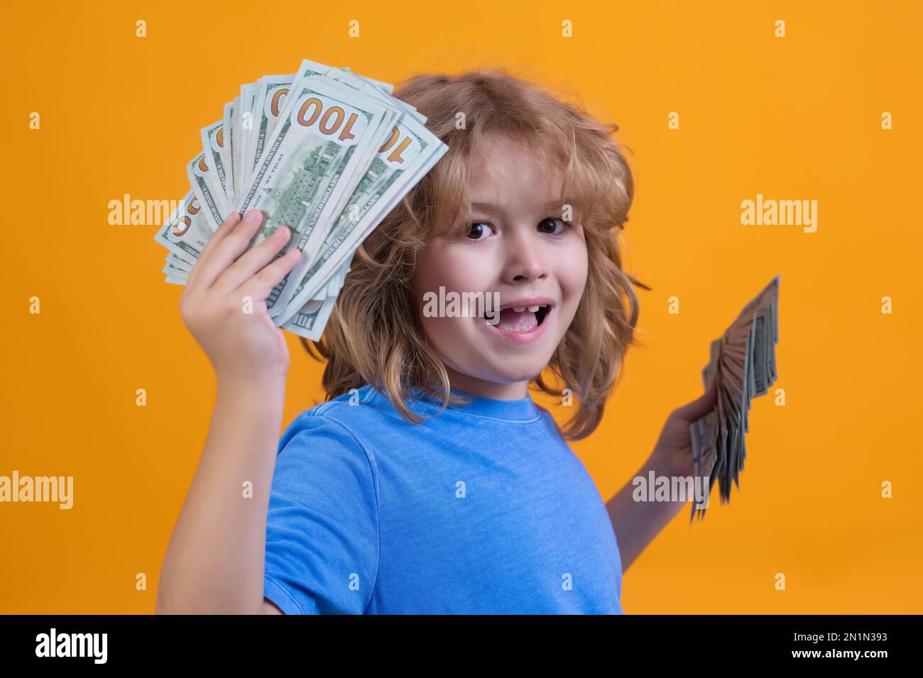 Kid showing money dollar bills, standing dreamy of rich against ...