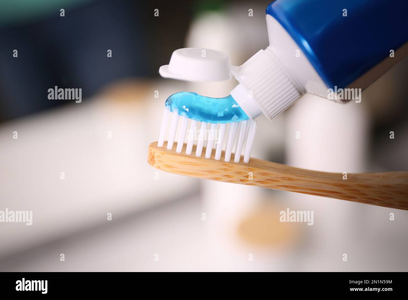 Applying toothpaste on brush against blurred background, closeup Stock ...