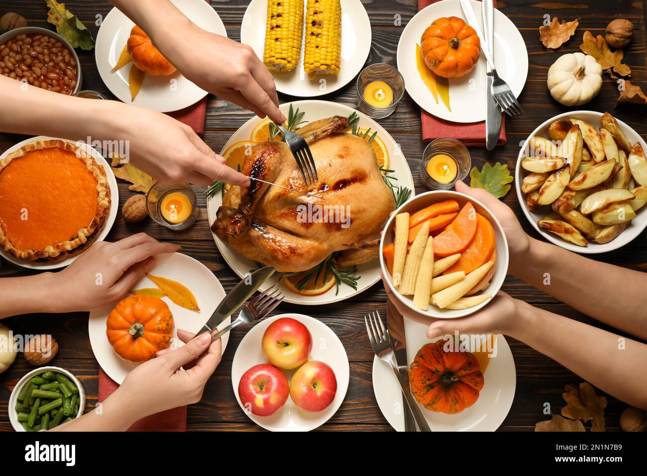 People eating cooked turkey at wooden table, top view. Thanksgiving day ...