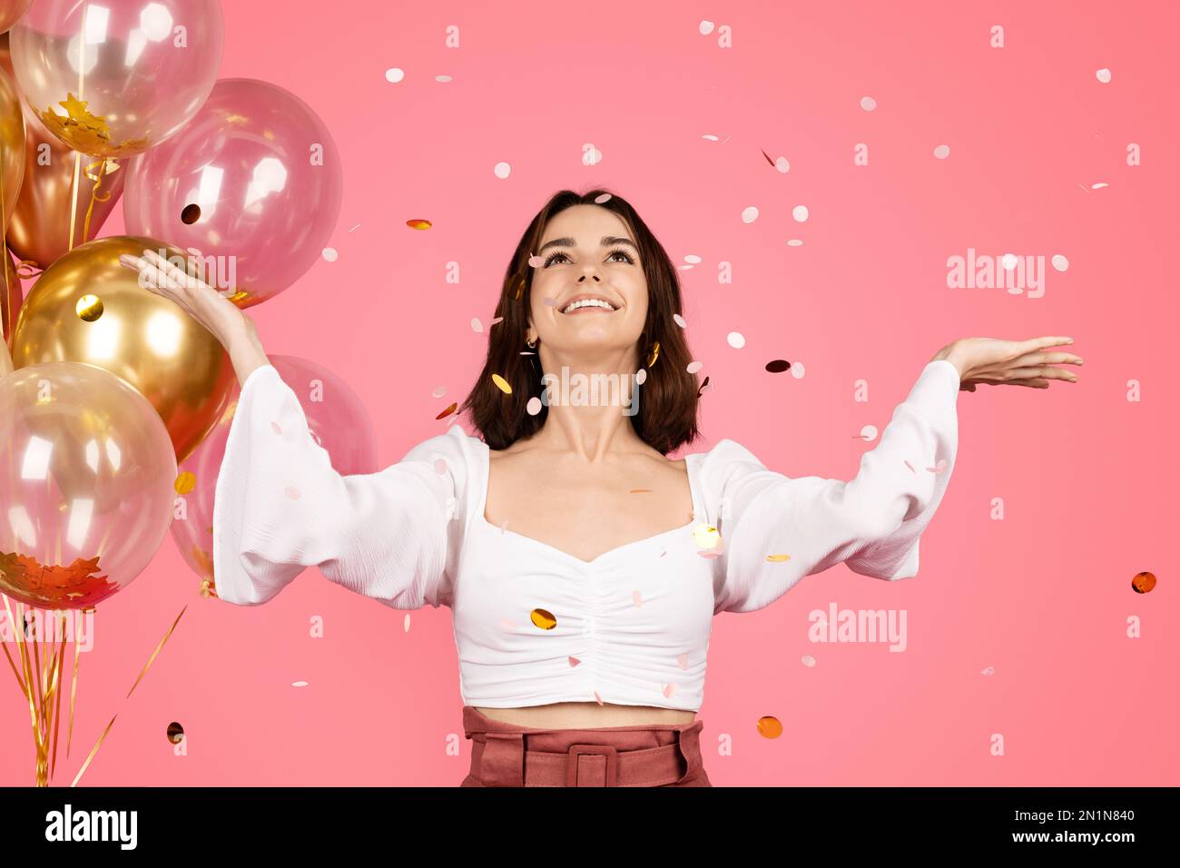 Satisfied inspired pretty young european lady with many balloons ...