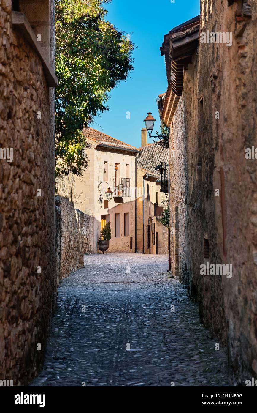 Narrow alley with stone buildings in the medieval town of Pedraza ...