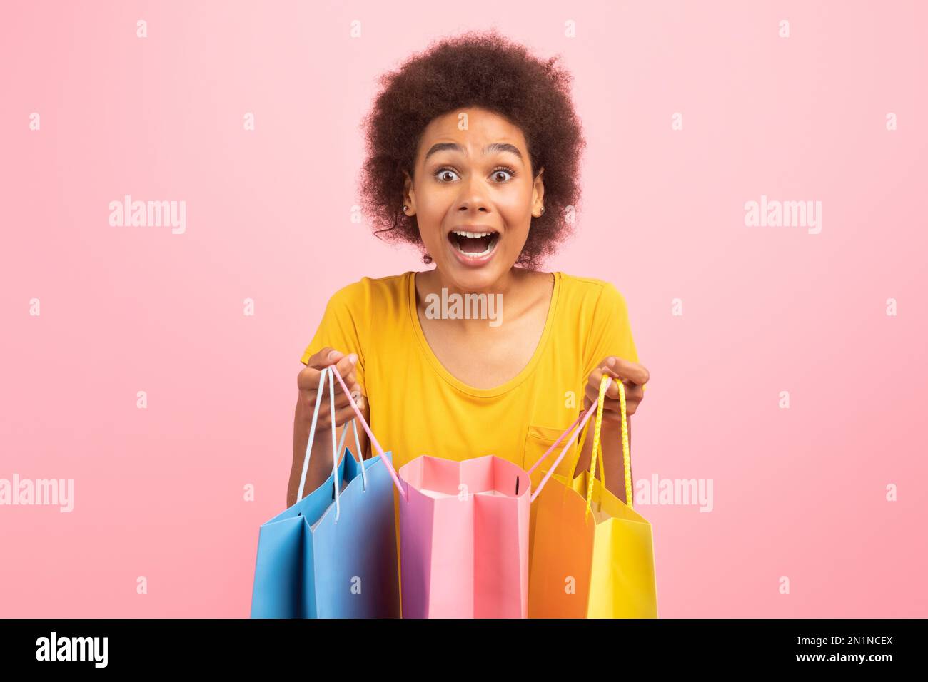 Happy shocked pretty young black curly lady with open mouth opens many ...