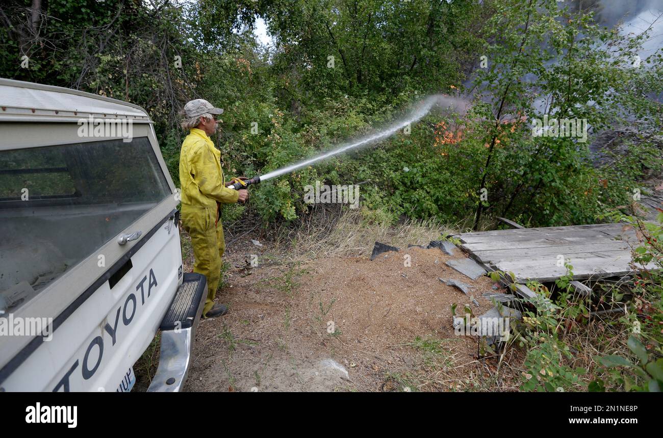 Oroville (Wash.) Assistant Fire Chief Jay Lynch hoses down flames at ...