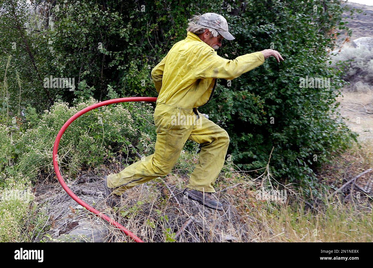 Oroville Assistant Fire Chief Jay Lynch leaps down a bank as he pulls a ...
