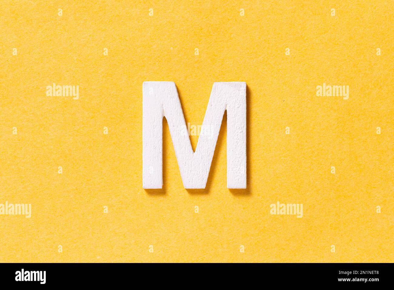 Letter M of the alphabet isolated on yellow background, top view Stock ...