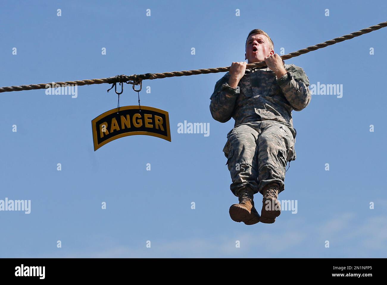 A U.S. Army Ranger does a pull up on a rope across a pond during ...