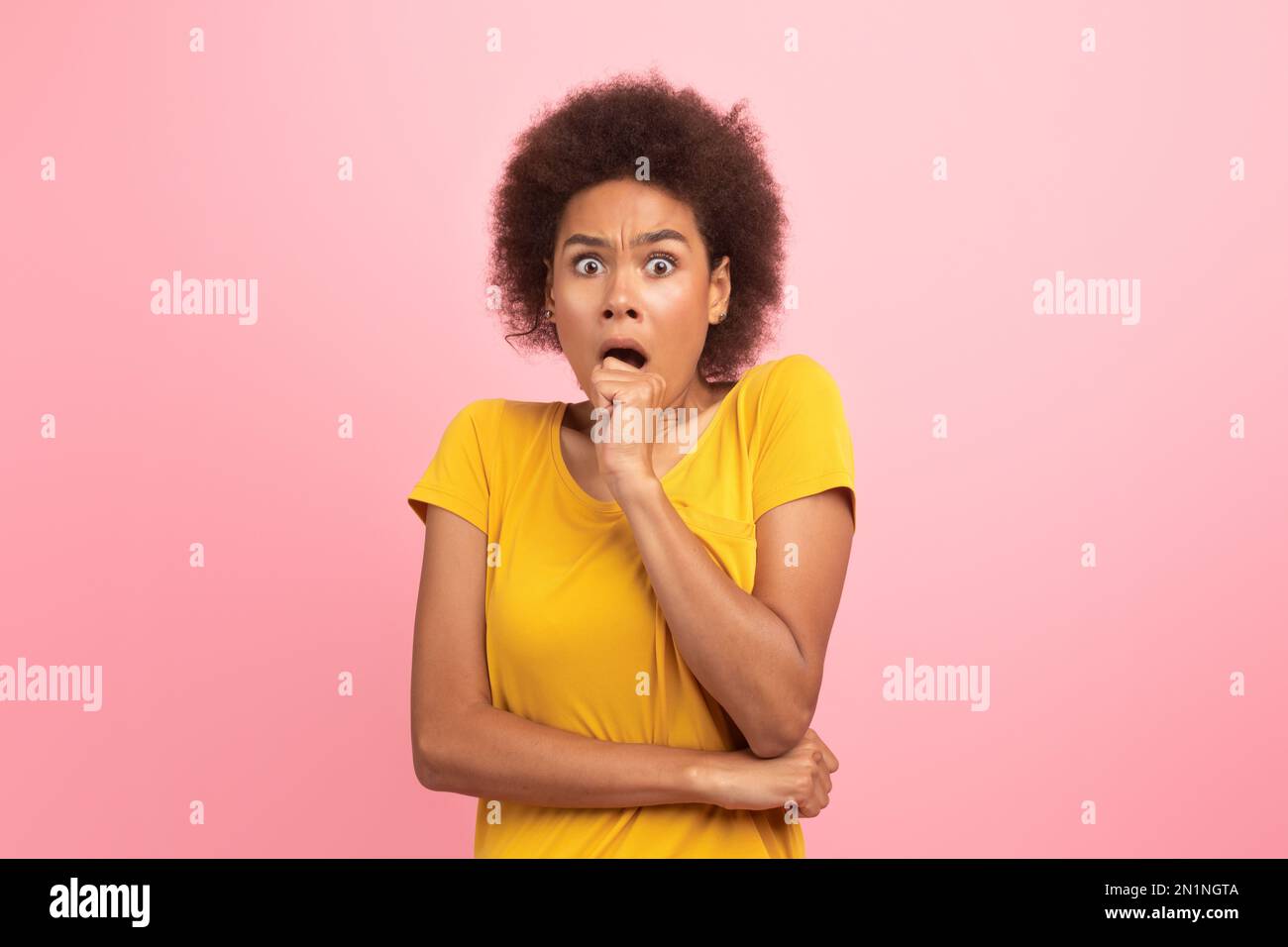 Frightened young black curly lady with open mouth scared and looking at ...