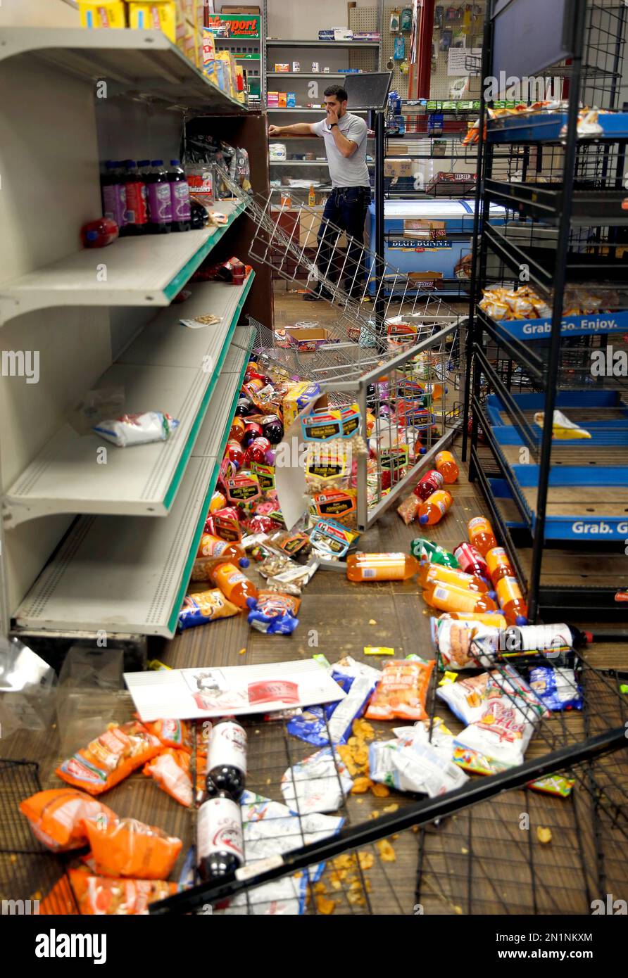 Adam's Market owner Sanad Motan stands inside his ransacked store ...