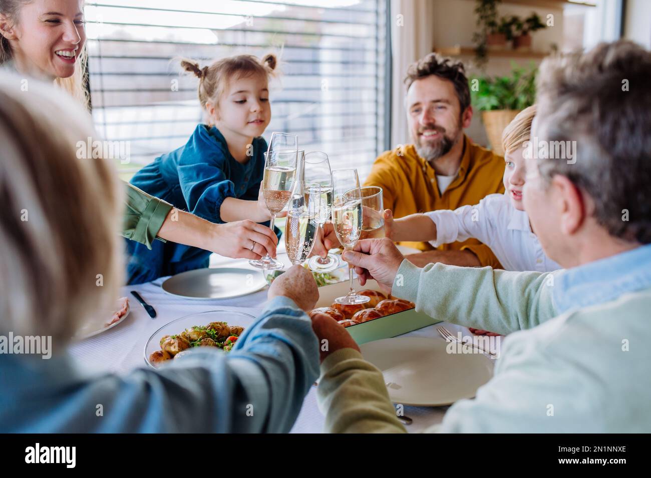 Happy family toasting before the Easter dinner Stock Photo - Alamy