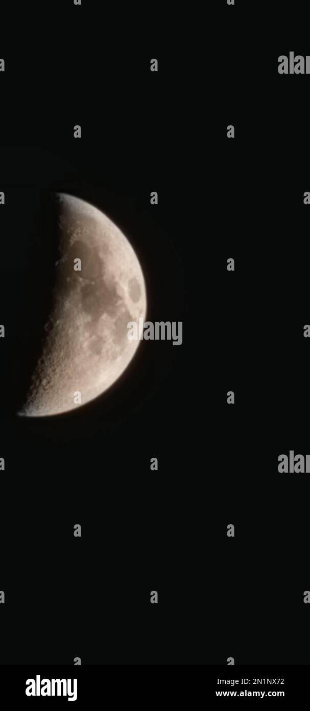 A vertical shot of the half-moon isolated on the empty dark black ...