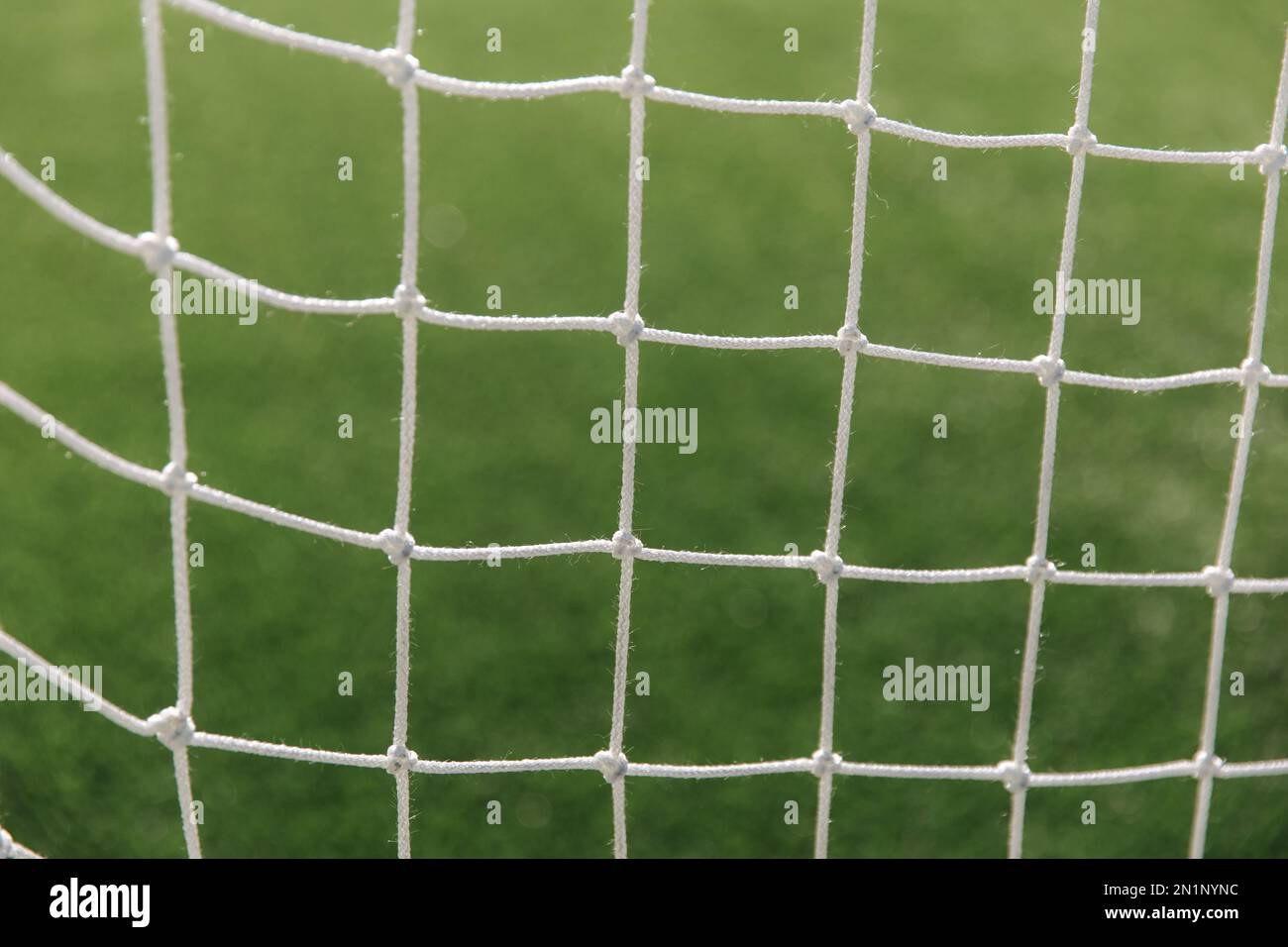 Soccer net background, view from behind the goal with blurred field ...