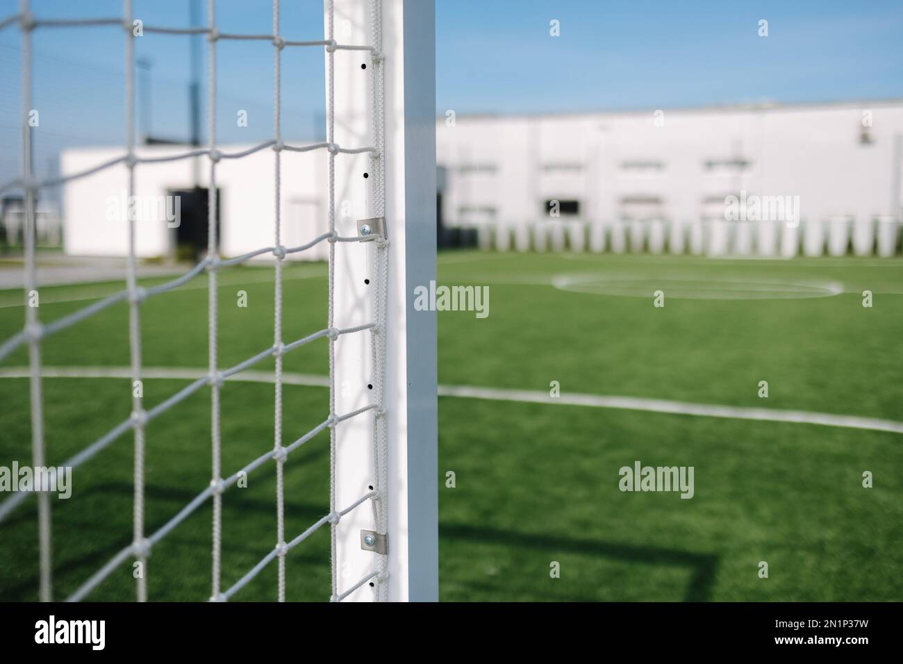 Soccer net background, view from behind the goal with blurred field ...