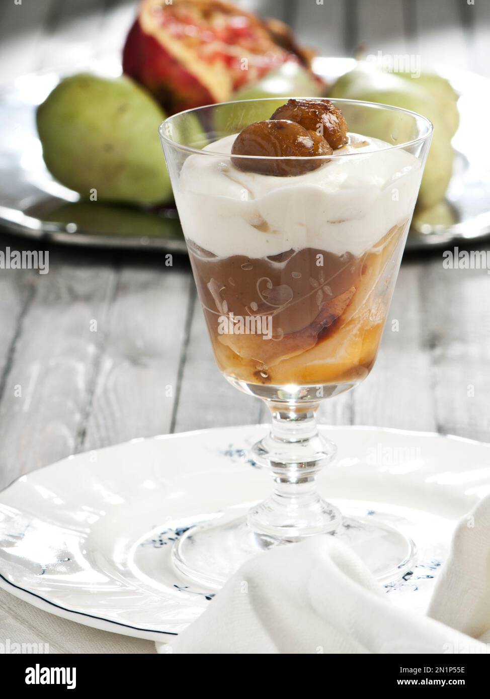 Baked pears with chestnut puree and cream on α highball glass. Grey ...